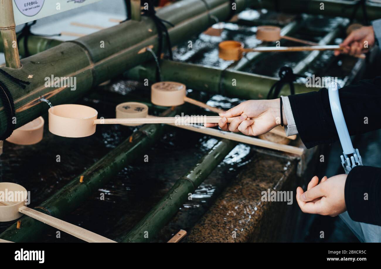 Girl washing her hands at Japanese temple Stock Photo - Alamy