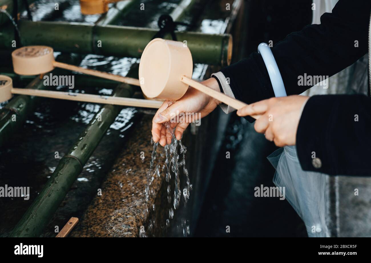 Girl washing her hands at Japanese temple Stock Photo - Alamy