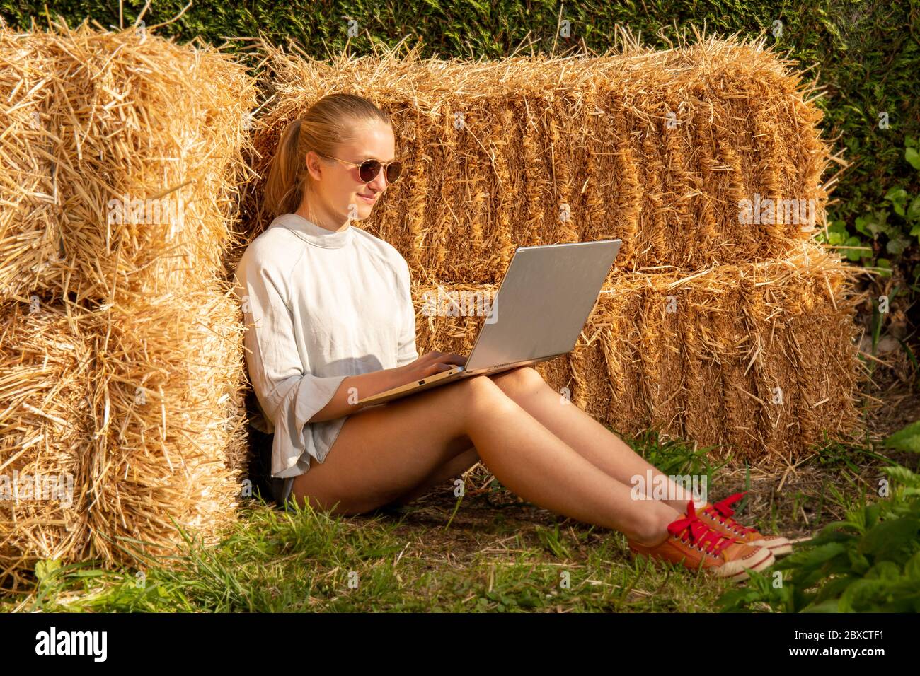 Young woman working on a laptop outside in a farm Stock Photo - Alamy
