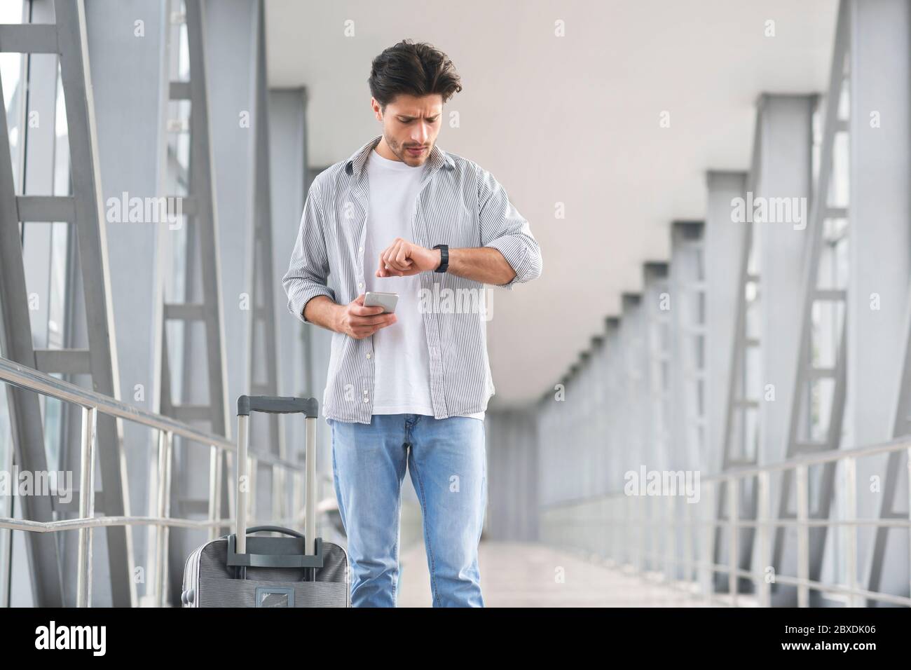Worry Man Looking At Wristwatch In Airport, Late For His Flight Stock ...