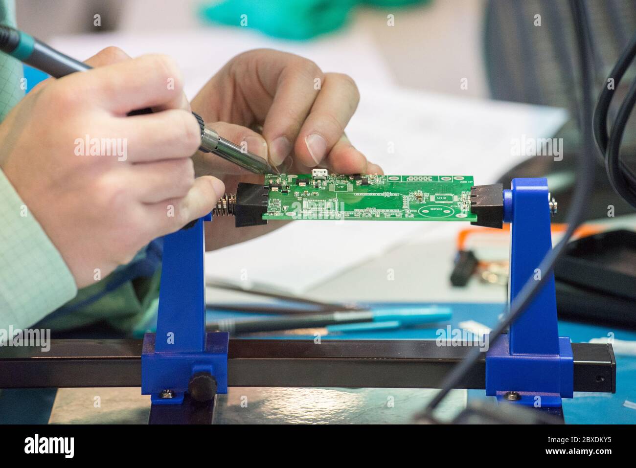 A person selects and solder the parts of the chip with a soldering iron ...
