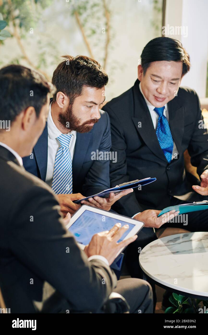 Business people discussing charts and diagrams at meeting and ...