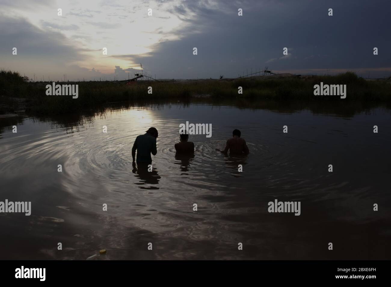 Small scale gold miners bathing on a rainwater pond in Galangan gold ...