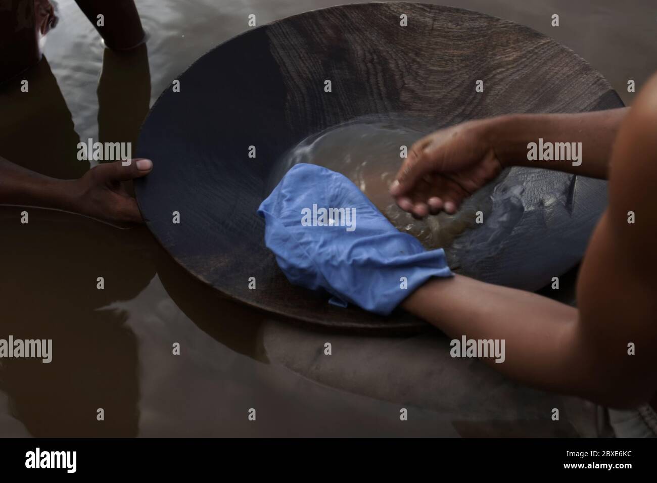 Small scale gold miners showing the process of gold panning, to create ...