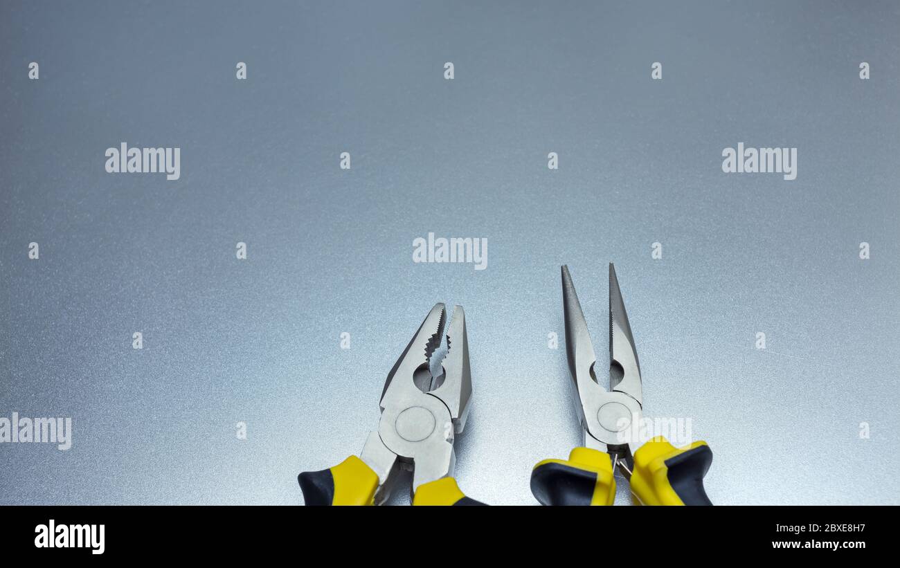 pliers and needle-nose pliers. closeup top view on metallic background ...