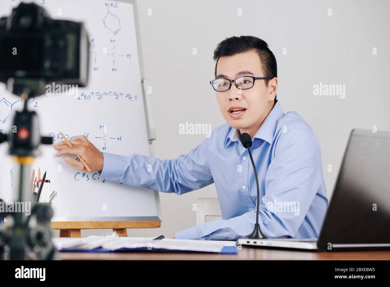 Young university teacher recording chemistry lesson on camera and ...