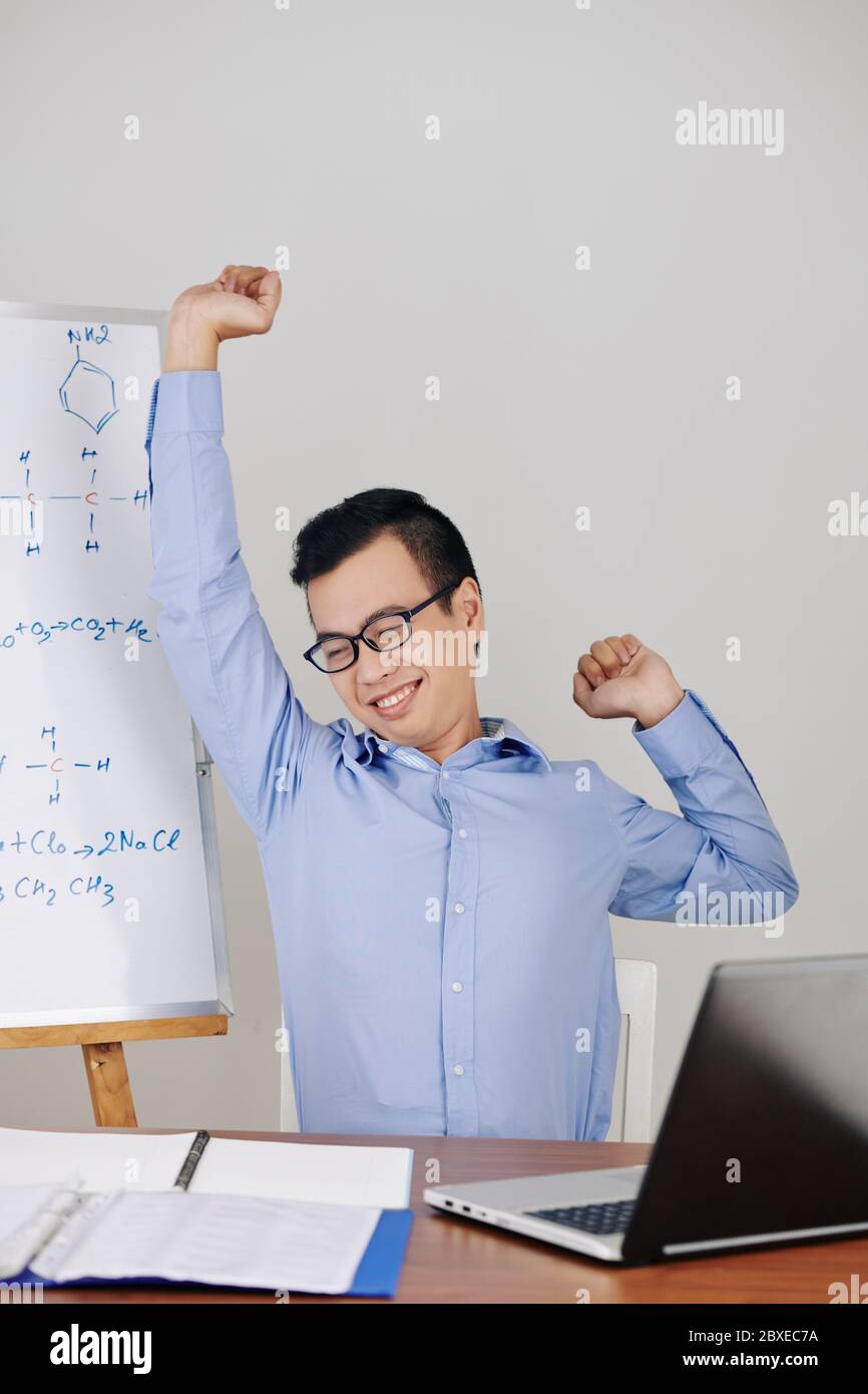 Young school teacher enjoying back stretch after conducting long online ...