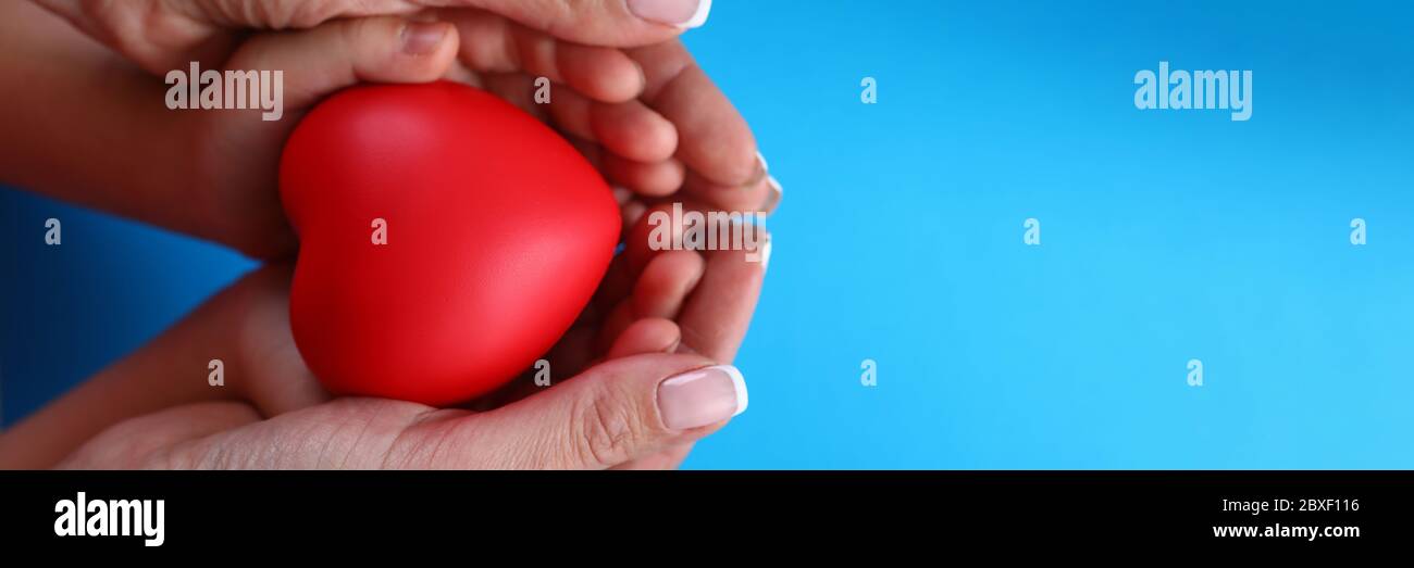 Close-up in female palms childrens hands and heart Stock Photo - Alamy