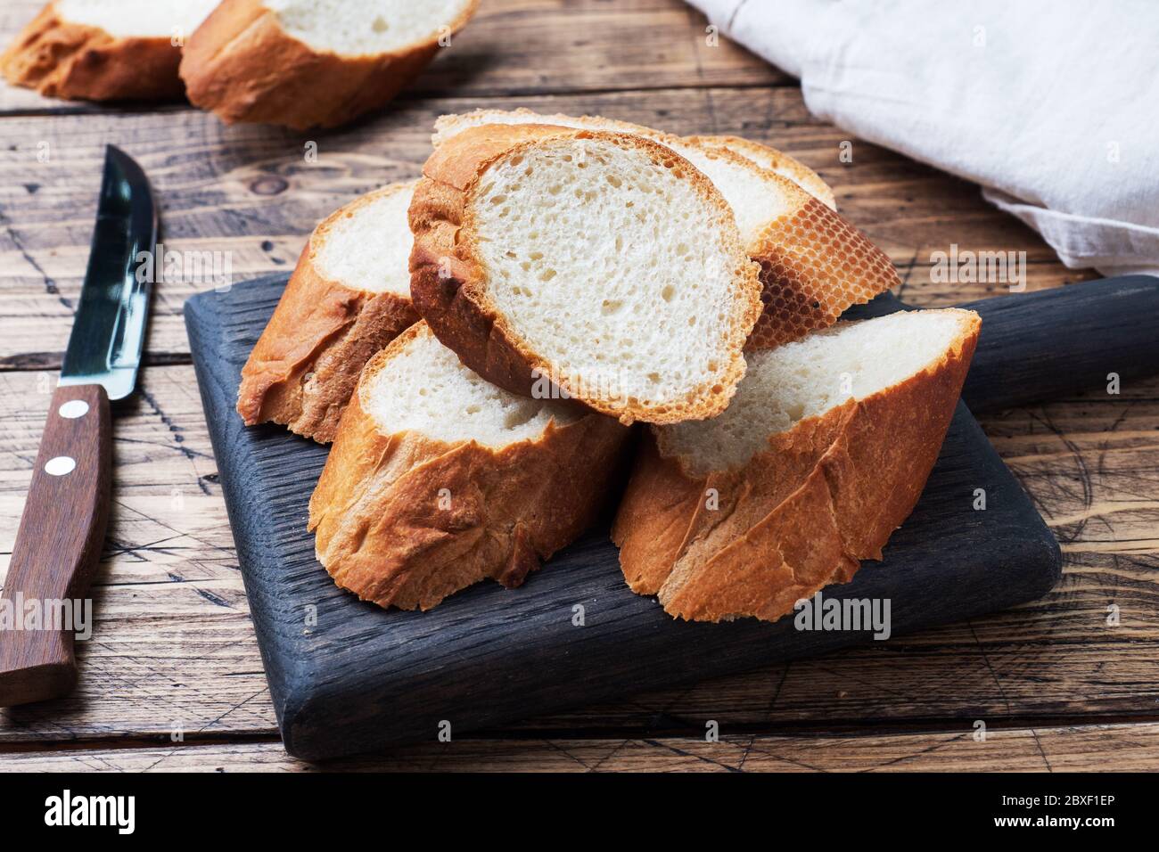 Fresh white bread baguette cut slays on a wooden cutting Board Stock ...