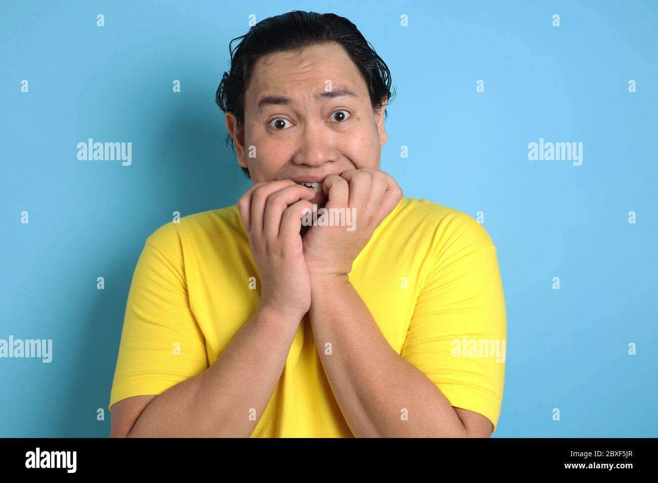 Scared man biting nails hi-res stock photography and images - Alamy