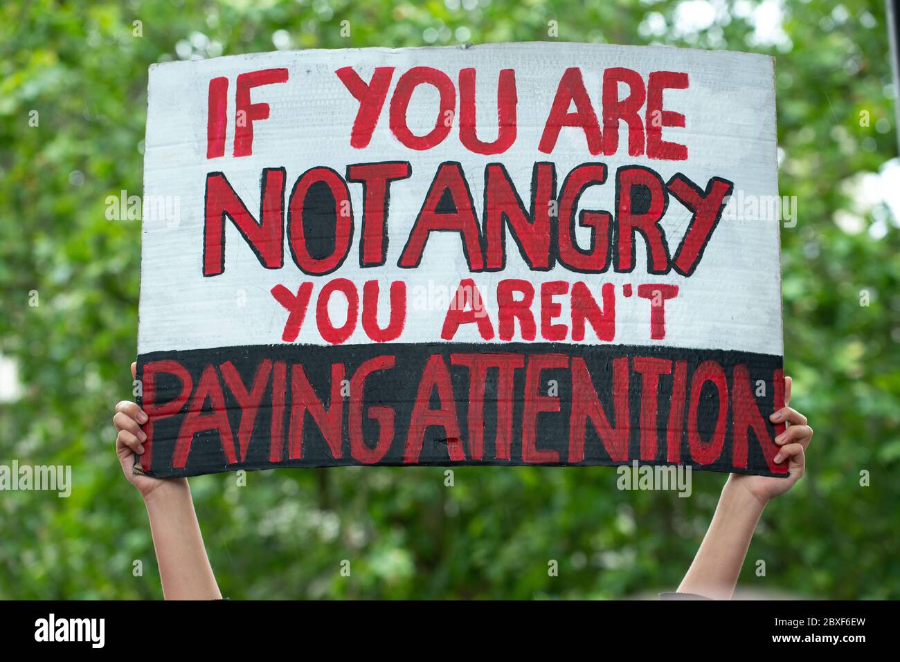 Protester holding up campaign / supportive poster/ sign, at the London ...