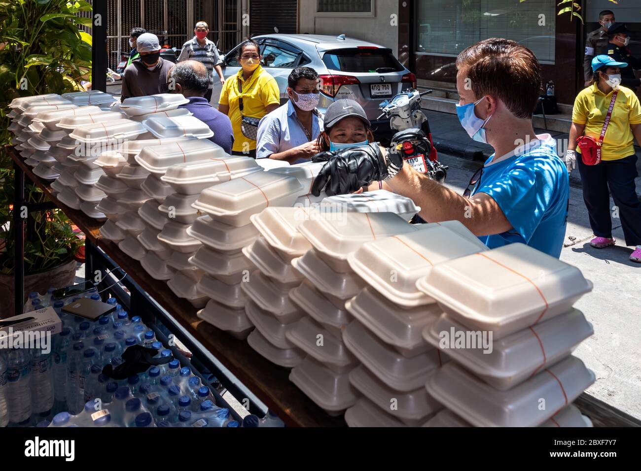 Volunteers giving out free food to poor people at food kitchen during ...