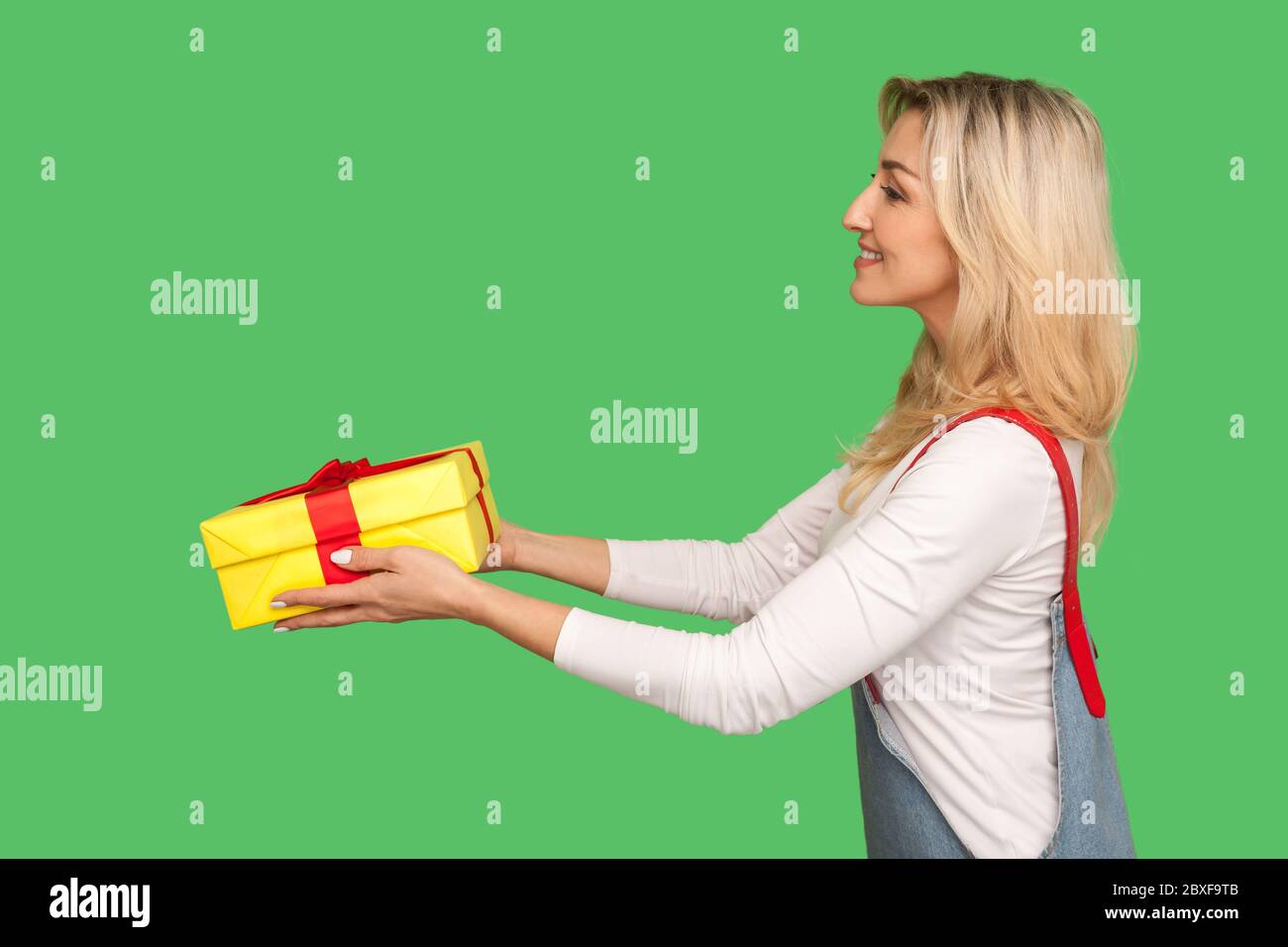 Take this present! Side view of generous beautiful adult woman with ...