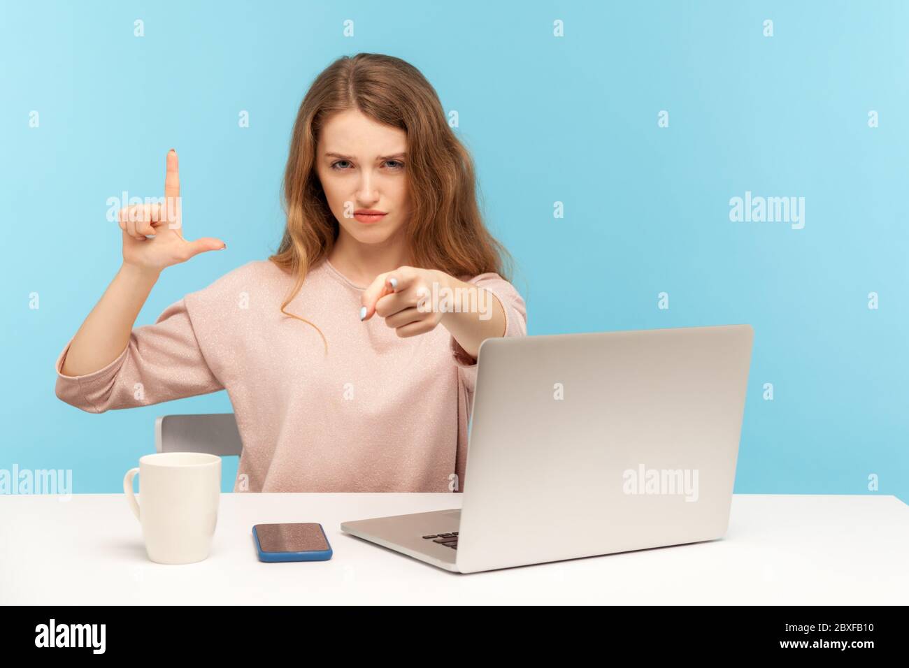 You are fired! Angry woman boss sitting at workplace and showing loser ...