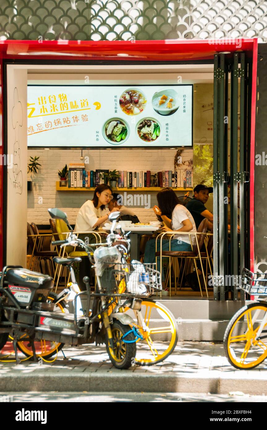 Two young Chinese ladies eating lunch at a noodle shop on Shanghai’s ...