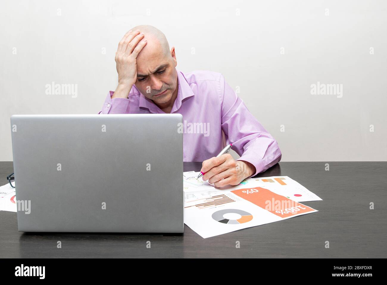 a worried man working, writing paper with boards a thoughtful ...