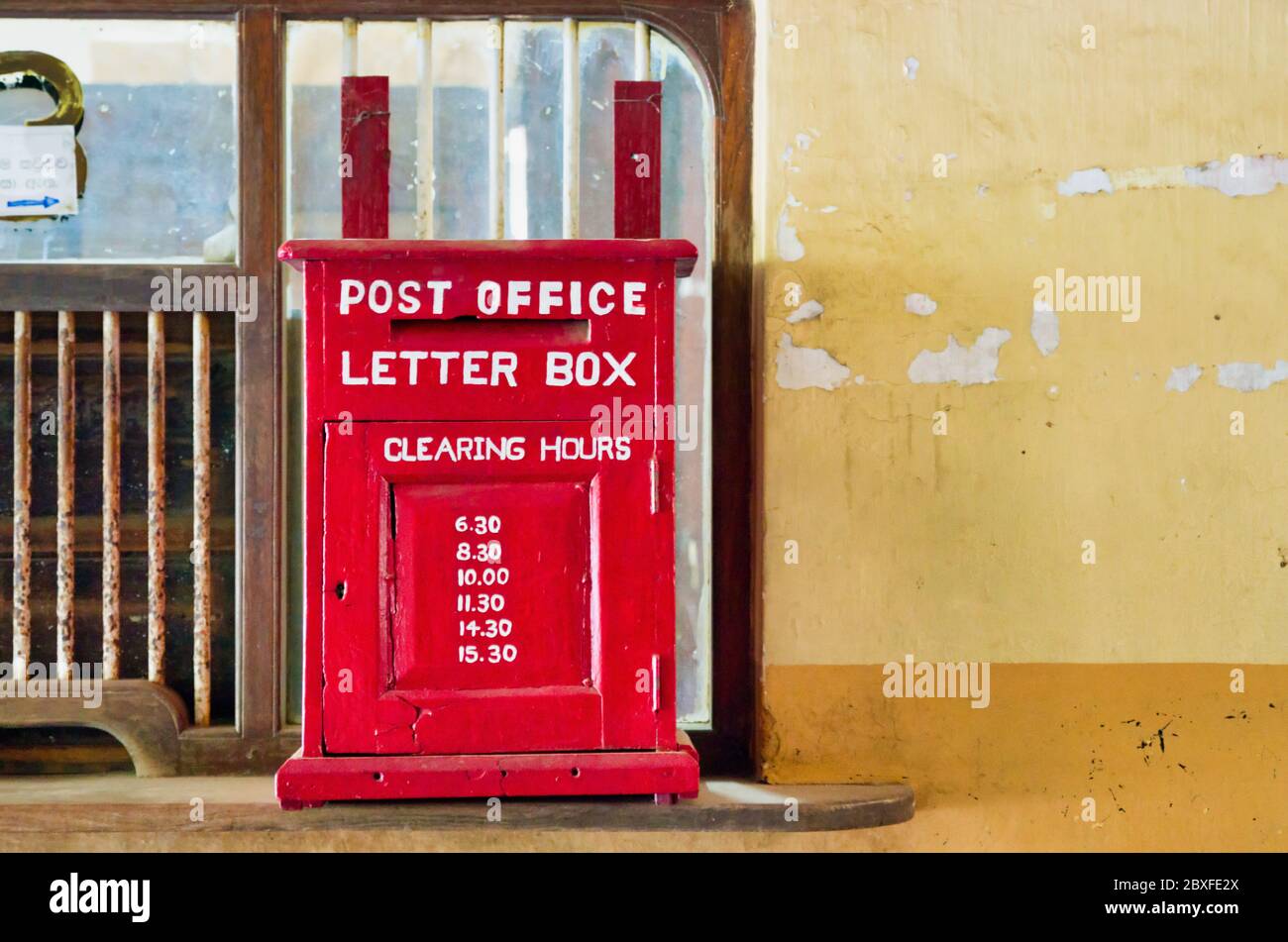 Vintage red vintage wood post office letter box with schedule in a ...