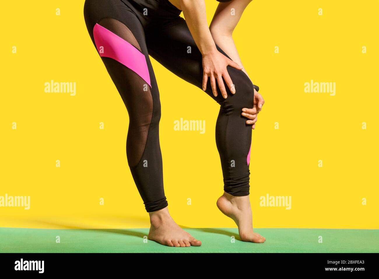 Closeup sportswoman touching painful knee, suffering joint injury after ...