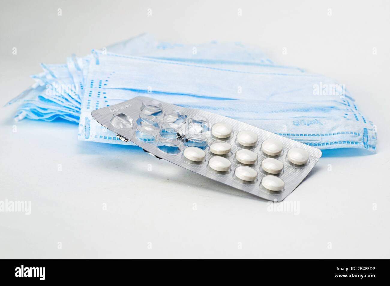 medical hygiene masks and pills in a blister pack lie on a white ...