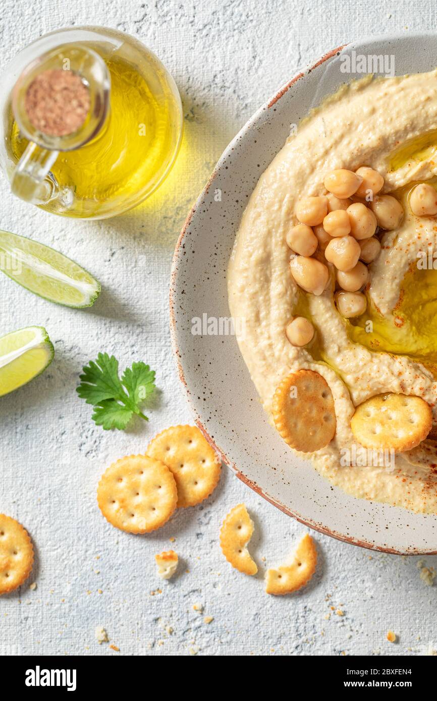 Enjoy your hummus with crackersi, coriander and lime Stock Photo - Alamy
