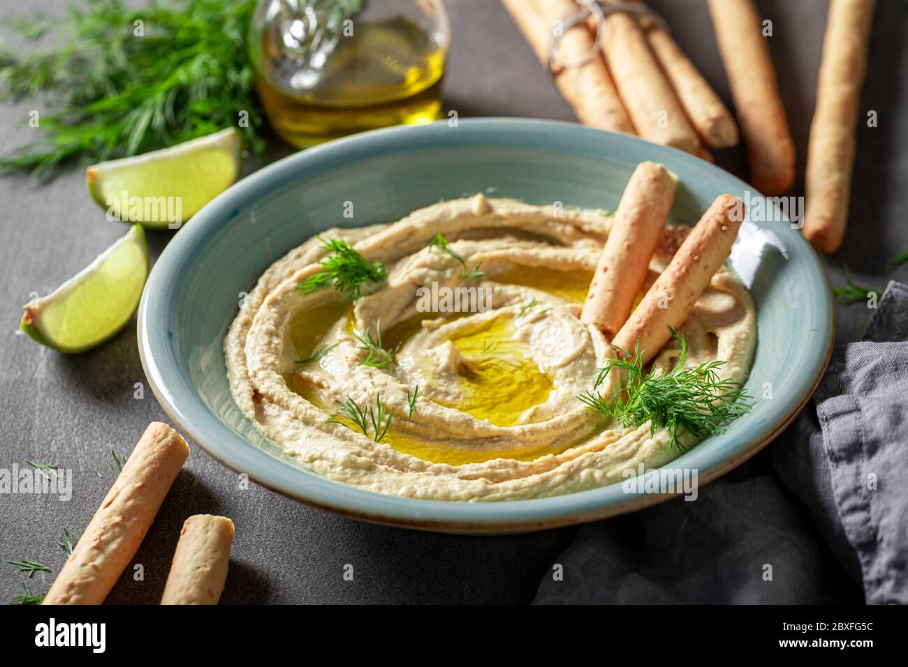 Homemade and tasty hummus with breadsticks and dill Stock Photo - Alamy
