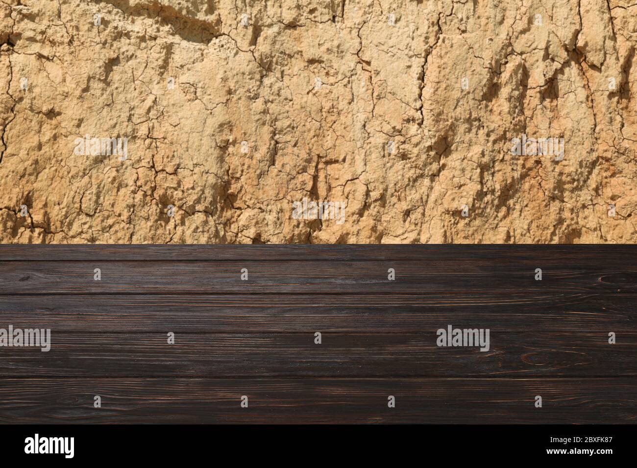 Wooden table against clay wall background. Mockup Stock Photo - Alamy