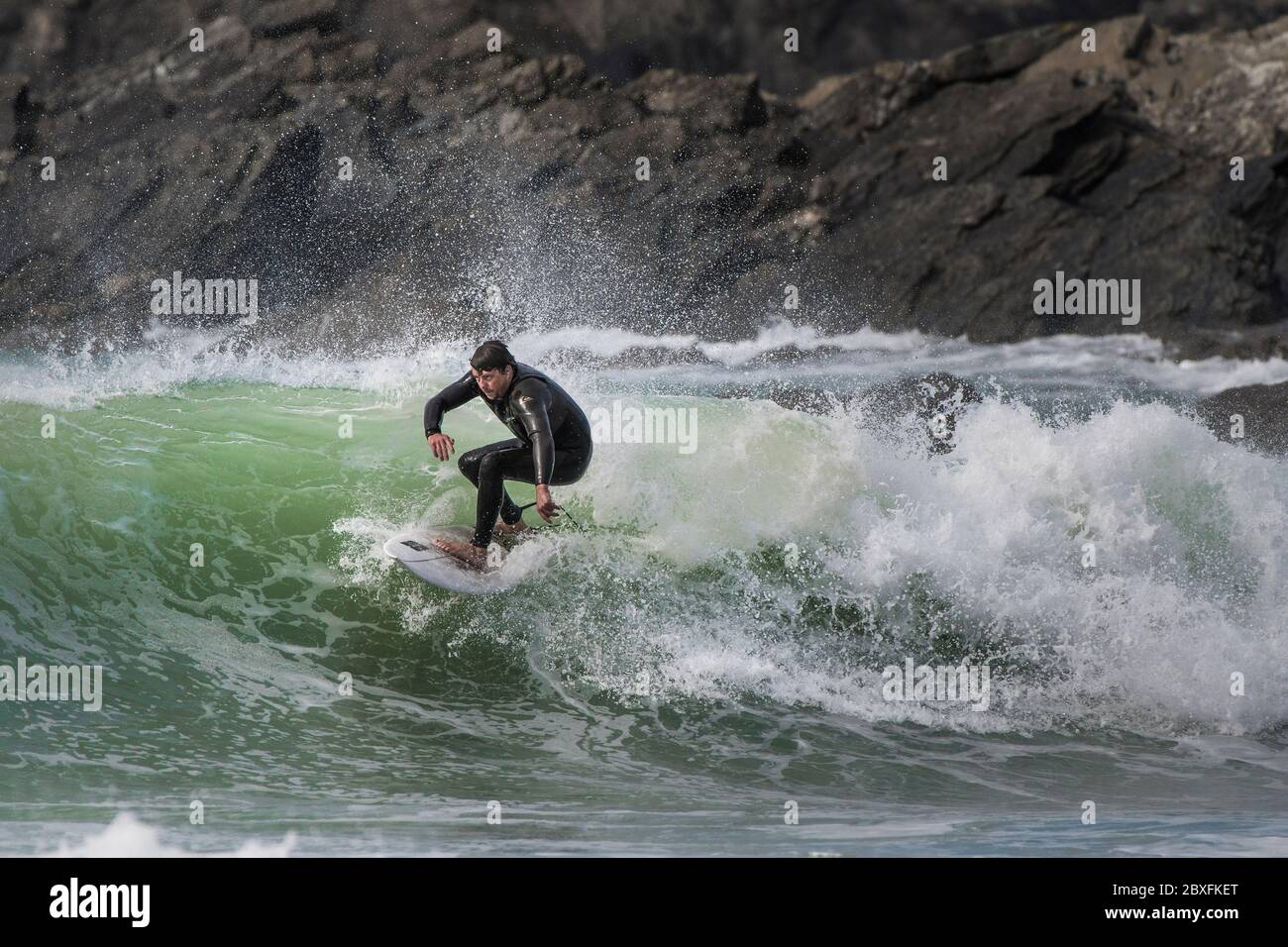 Spectacular action as a determined male surfer rides a wave at Fistral ...
