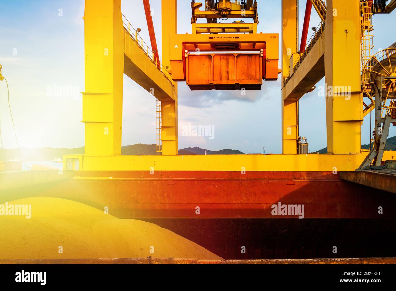 Raw sugar bulk loaded into large vessel hole by rotainer for export ...