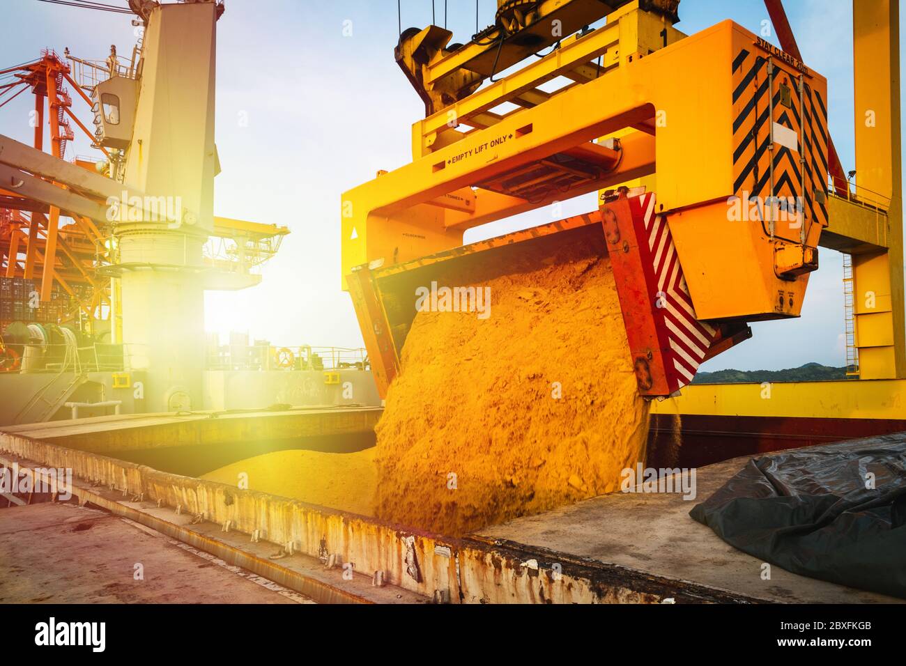 Raw sugar bulk loaded into large vessel hole by rotainer for export ...
