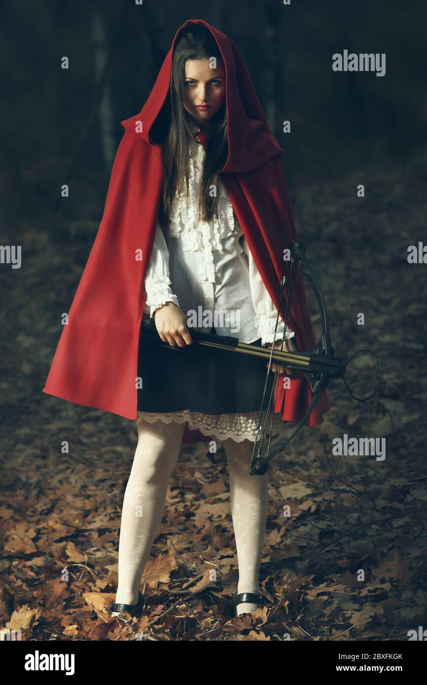 Dangerous gaze from Little red riding hood with crossbow in the forest ...