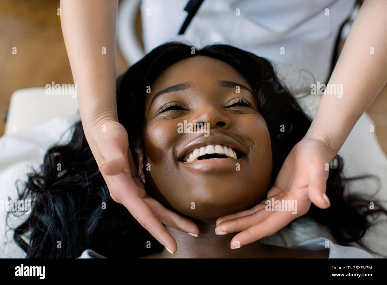 Close-up of hands of cosmetologist woman making special face massage to ...