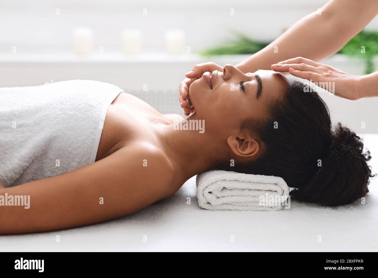 Facial spa massage for young african lady Stock Photo - Alamy