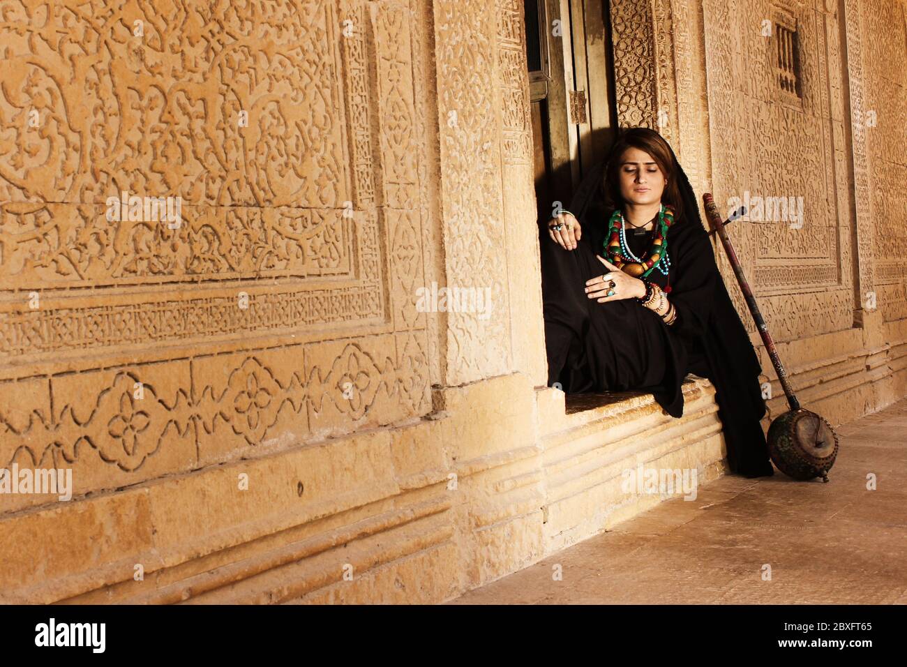Beautiful girl as a malang with musical instrument on shrine Sindh ...