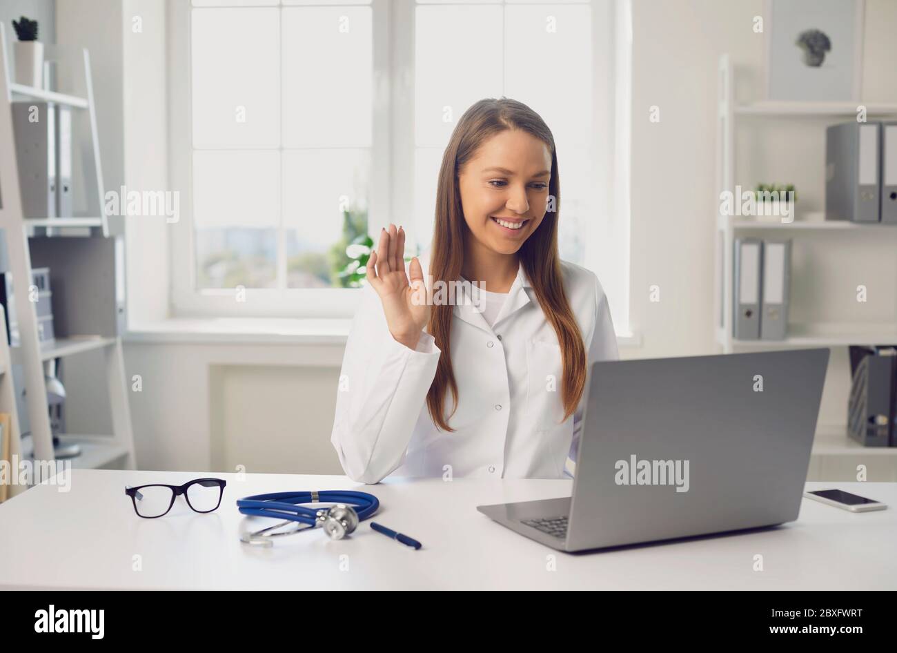 Female doctor conducting telemedicine consultation via laptop. Virtual ...
