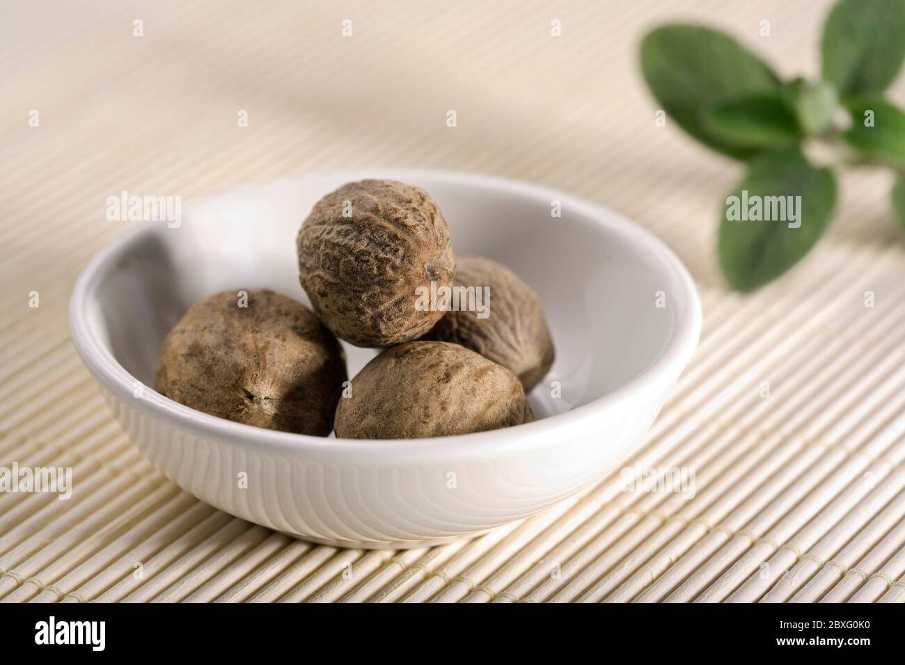 nutmeg in small bowl on placemat garnished with leaves Stock Photo - Alamy