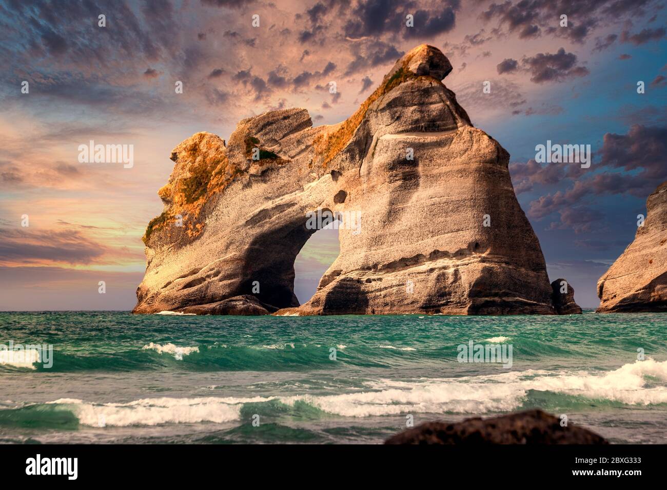 Amazing sunset over famous rock formations on the Wharariki beach in ...