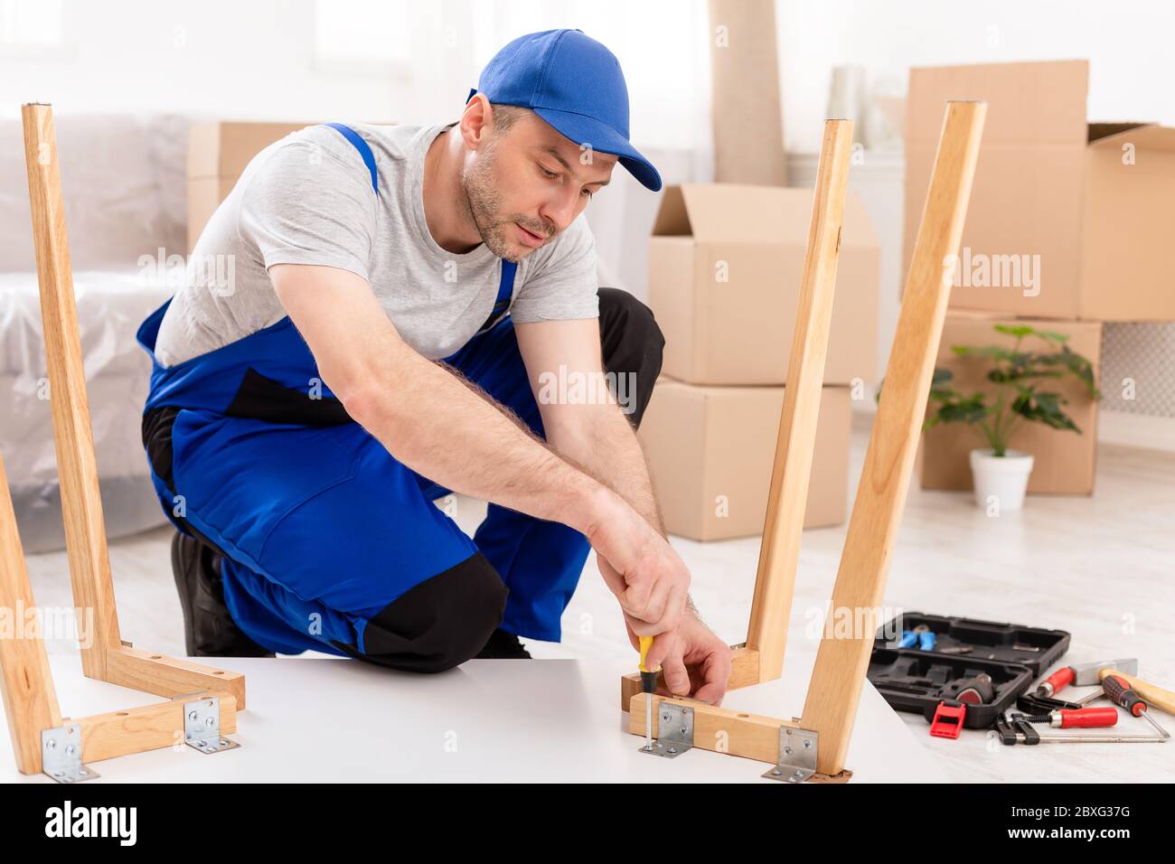 Carpenter Working Assembling Desk Installing Furniture After Relocation ...
