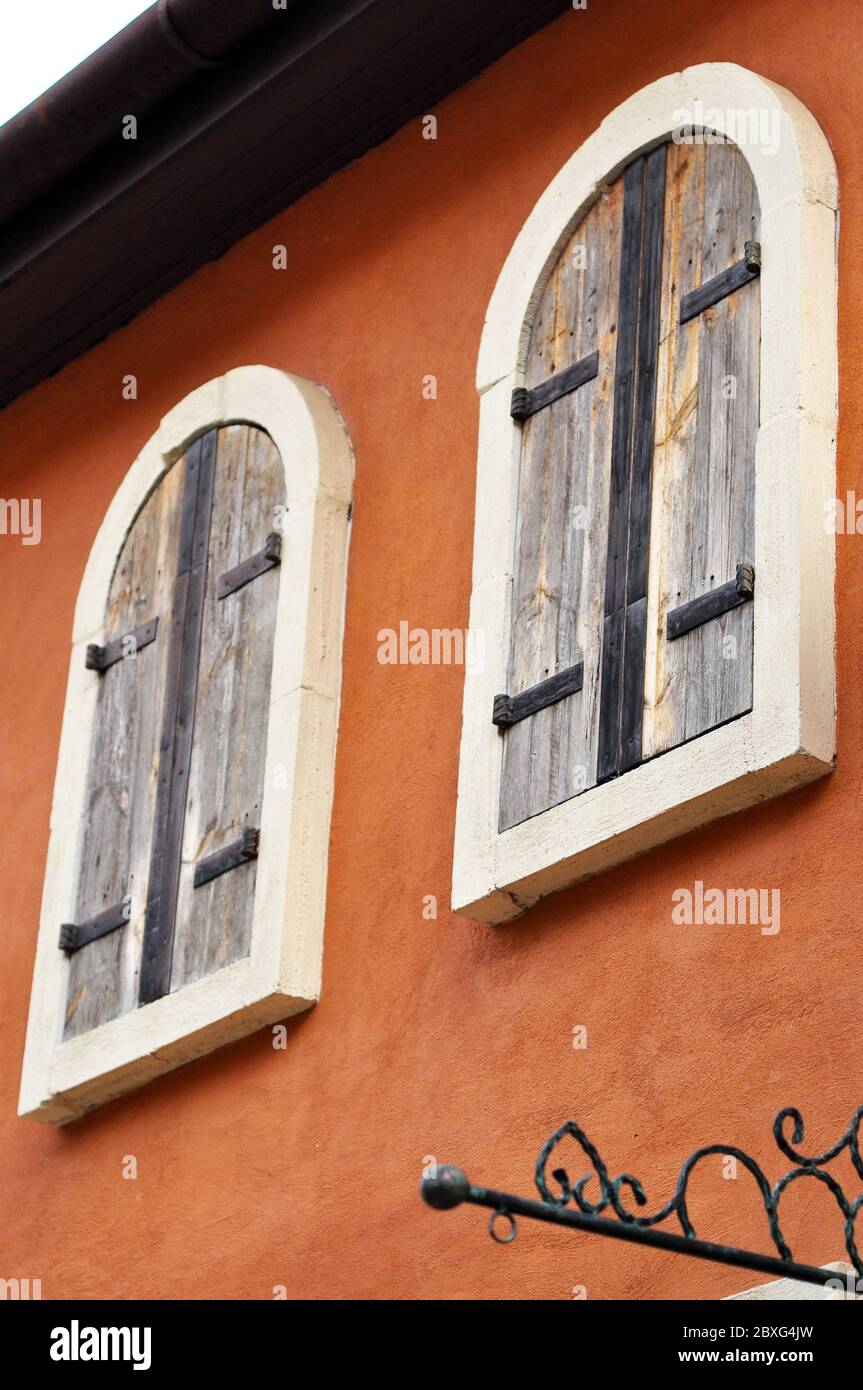 European style wooden windows, rounded corners on the brown wall Stock ...