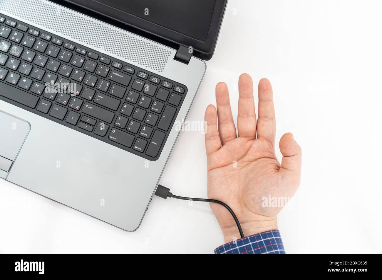 Augmented human hand connected to a laptop via usb cable and ...