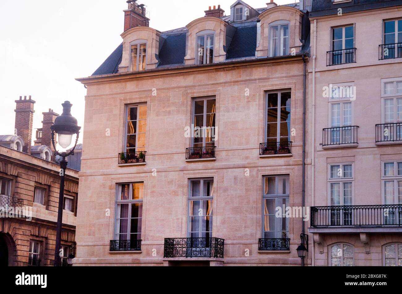 Iron balconies, curved dormers and tall windows with transoms in Paris ...