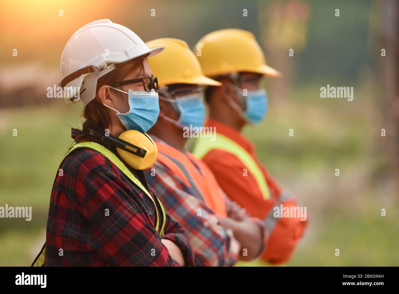 Three engineers on a building site wearing face masks, Thailand Stock ...