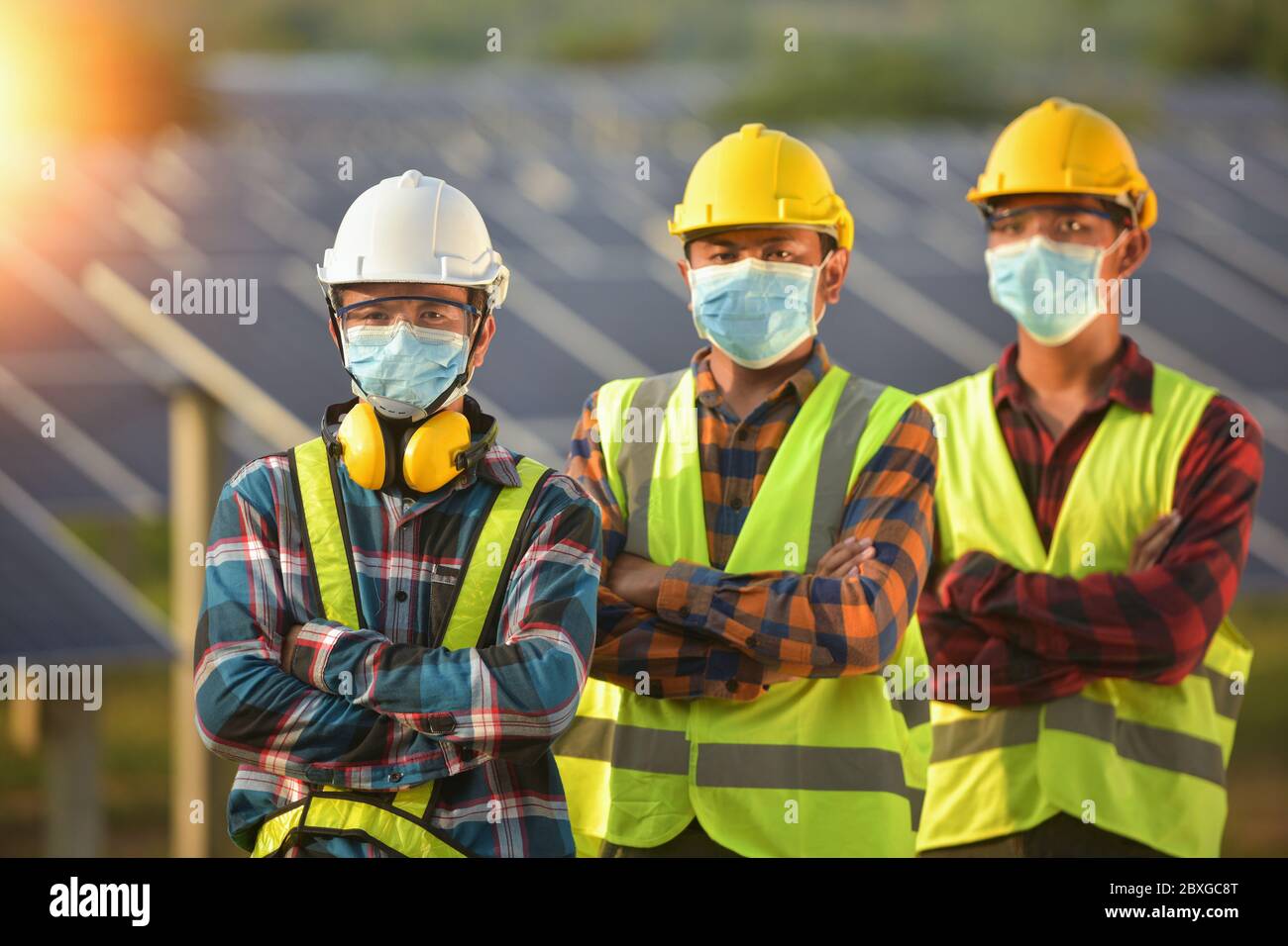 Three engineers at a solar powered station wearing face masks, Thailand ...