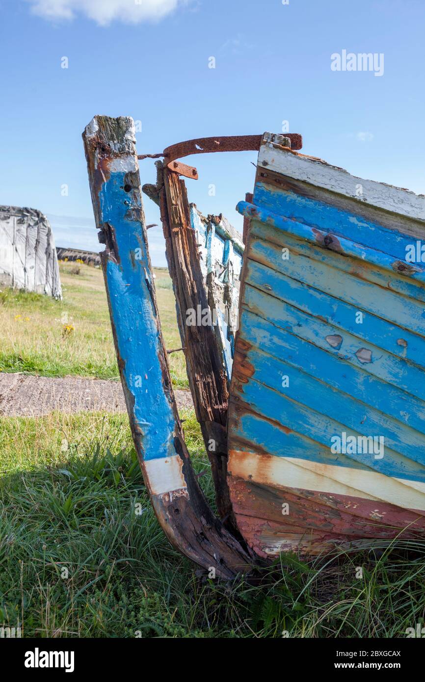 The hull of an abandoned decaying fishing boat rotting on the shore at ...
