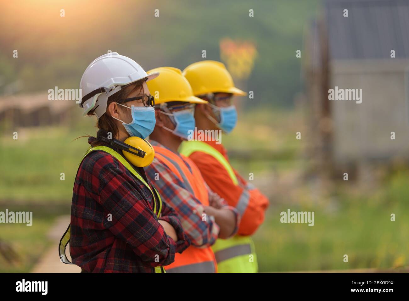 Three engineers on a building site wearing face masks, Thailand Stock ...