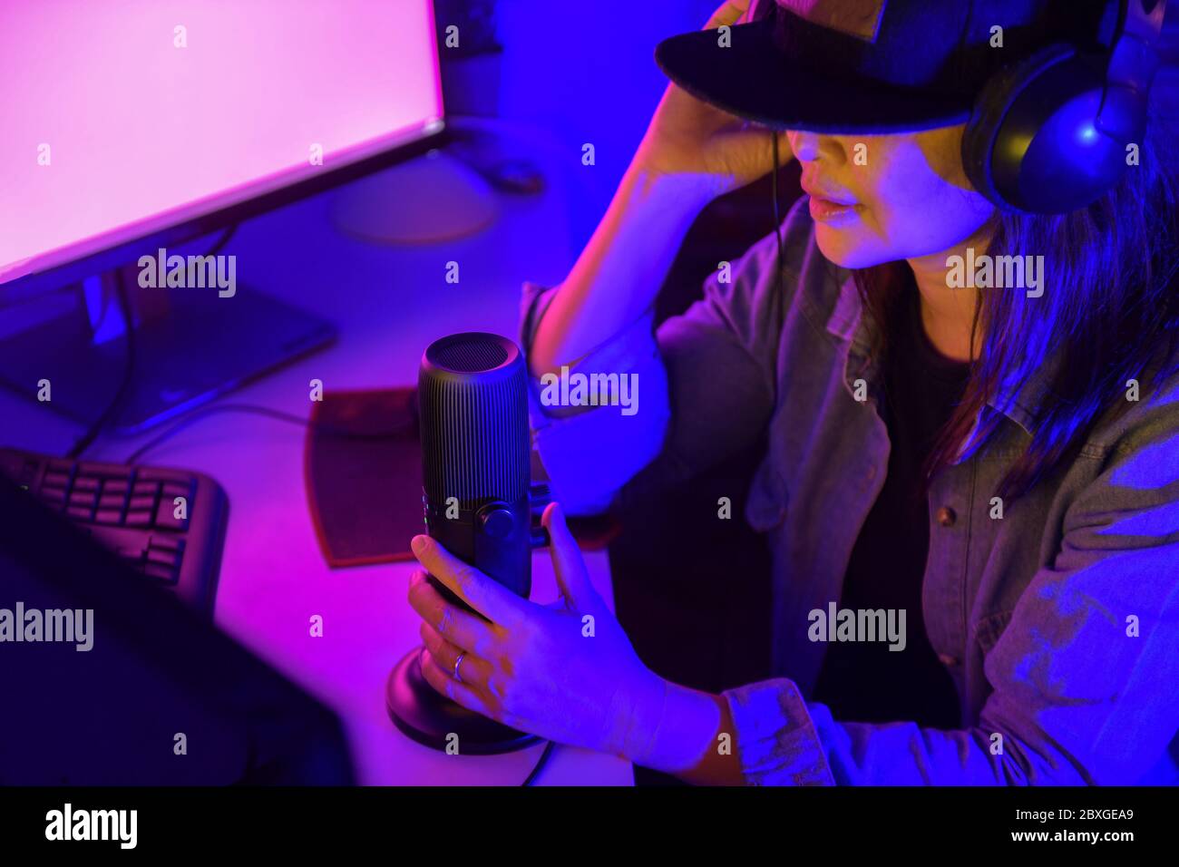 Female vlogger sitting at a desk live streaming Stock Photo - Alamy