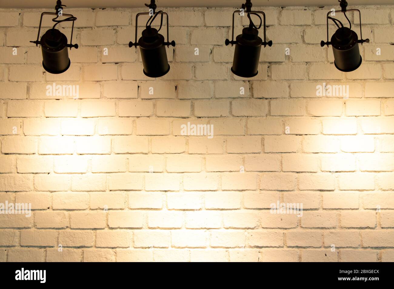 Hanging spotlight illuminate at brick wall background with copy space ...