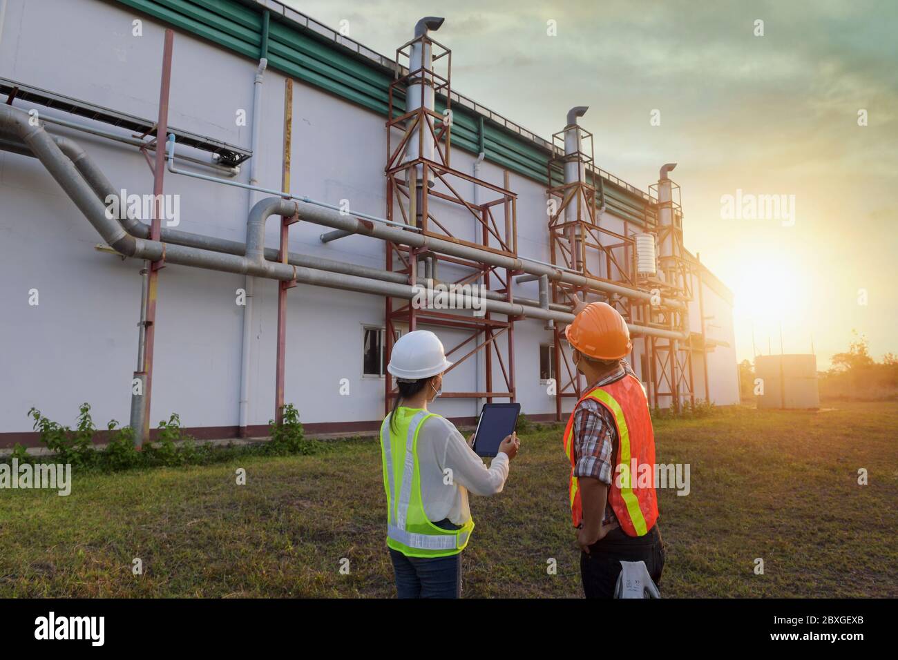 Two engineers standing outside a power plant, Thailand Stock Photo - Alamy