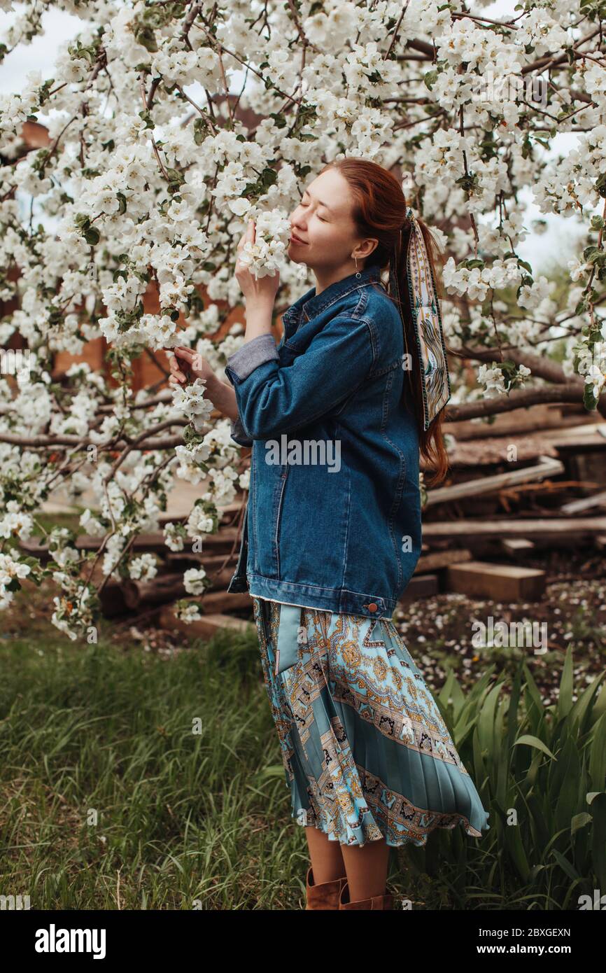 Smiling woman smelling a cherry blossom tree, Russia Stock Photo - Alamy