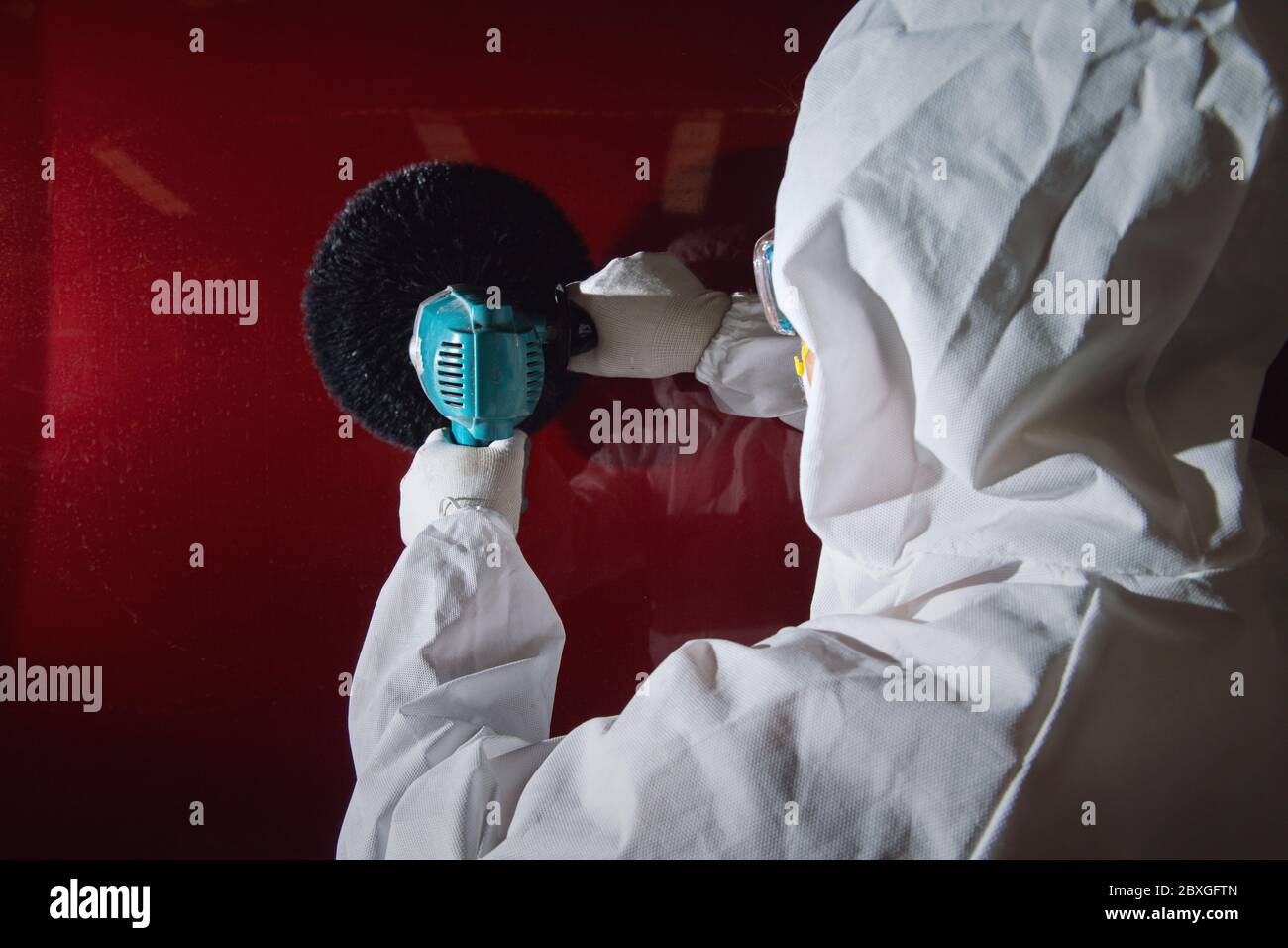 Mechanic wearing a clean suit polishing a car Stock Photo - Alamy