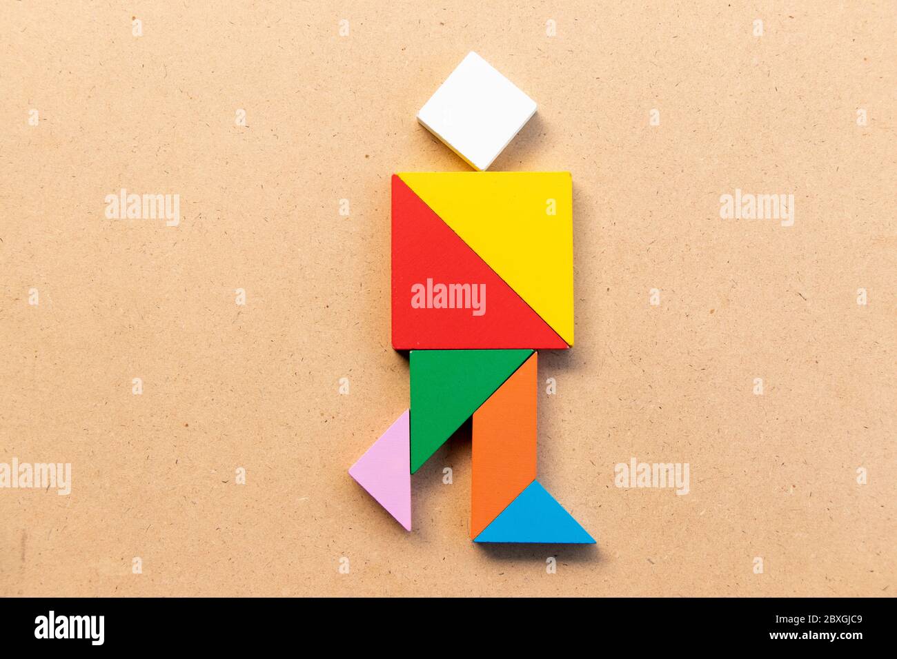 Color tangram puzzle in walking man shape on wood bacground Stock Photo ...
